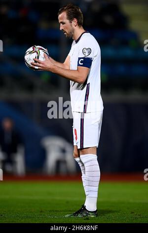 Harry Kane of England holds the match pennant as he adjusts his socks ...