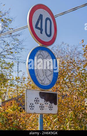 Snow chains mandatory road sign below a speed limit sign along a ...