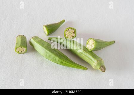 Small pile of green okra on a white background Stock Photo - Alamy