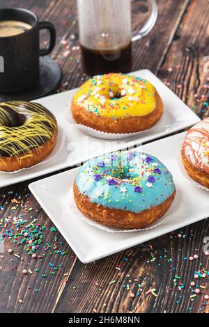 Delicious donuts decorated with different decorations on wooden table ...