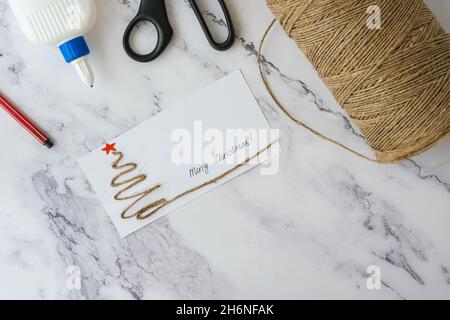 DIY ribbon rope, scissors used to create individual greeting card merry ...