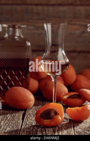 Apricot liquor and fresh apricots on a old wooden table. Wine and juicy ...