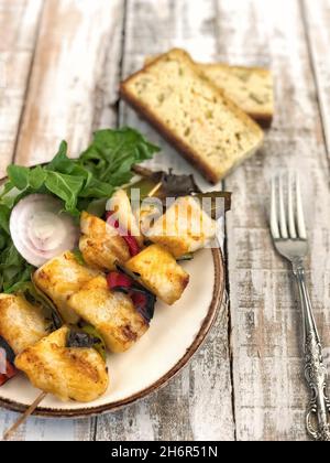 Skewed sole fish served with salad on a wooden table Stock Photo - Alamy