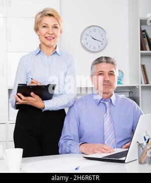 Office routine. Female assistant manager discussing statistics with ...