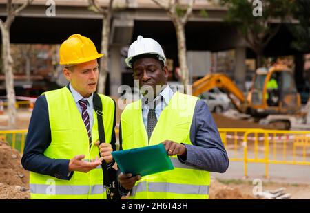 Portrait of an engineer and architect with folder of documents at ...
