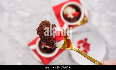 Chocolate mug cakes garnished with whipped cream and chocolate hearts ...