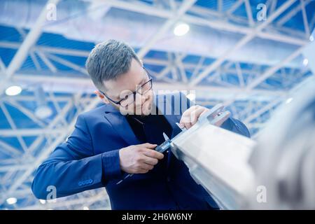 Engineer checks dimensions with vernier caliper control quality of ...