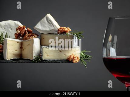 Red wine and soft cheeses with walnuts and rosemary. Copy space Stock ...
