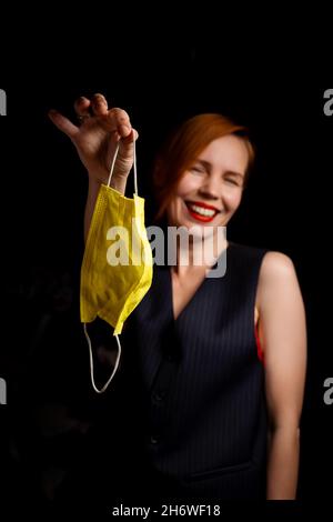 Freedom from the medical mask. Woman laughs contentedly holding a ...