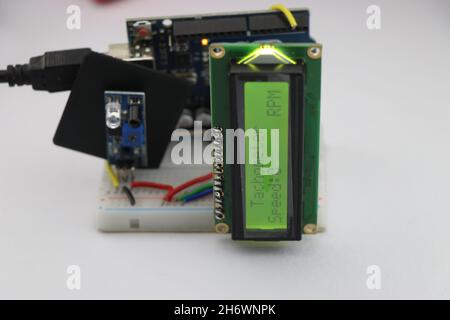Breadboard circuit made from display module and microcontroller board connected with wires shows ...