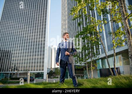 successful man in formalwear with computer outside the office ...