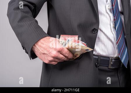 Businessman removing euro banknotes from his pocket Stock Photo - Alamy