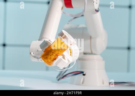Robot arm with a pills in bottle in the laboratory. The concept of ...