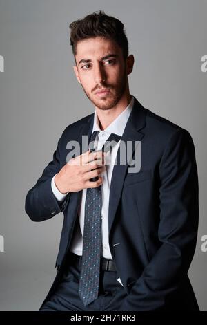 Handsome, fit shirtless young man undoing pants' belt to undress, on ...