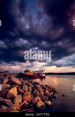 A mesmerizing shot of a cloudy sky over a green field, a tree in the ...