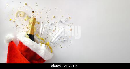 Champagne bottle with confetti, glasses and christmas decor on colored ...