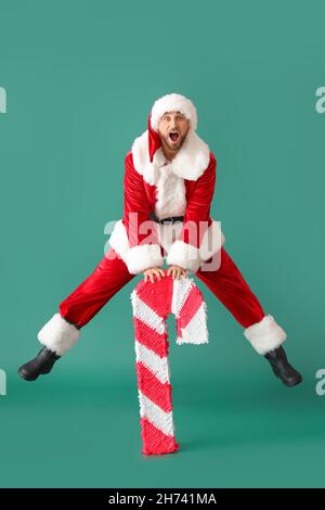 Jumping Santa Claus with candy cane pinata on green background Stock ...