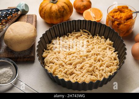 Baking dish with uncooked pumpkin pie and ingredients on wooden ...