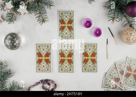 Tarot cards spread on white concrete surface with Christmas tree ...