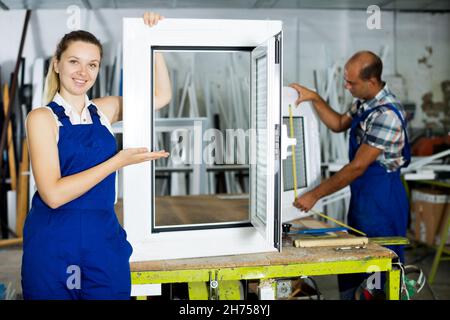 Portrait girl in workwear with finished window from pvc profile at ...