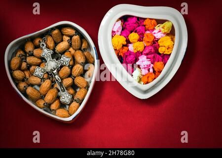 Red paper heart and wooden crucifix cross on top of open bible ...