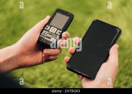 The Human Hand Picks an Old Phone That Lies Near New Smartphones Stock ...