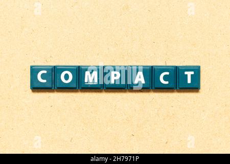 Tile alphabet letter with word compact in red color rack on wood ...