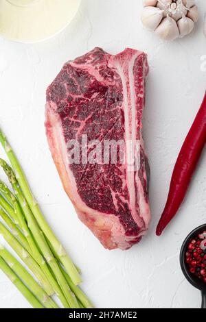 Raw club steak with ingredients set, on old dark wooden table ...