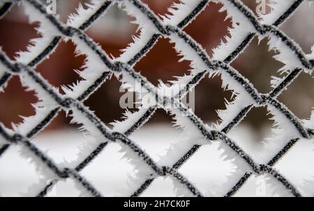 Frozen icy metal grid covered with snow Stock Photo - Alamy
