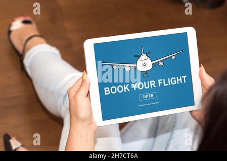 Tablet screen displaying a flight booking concept Stock Photo - Alamy