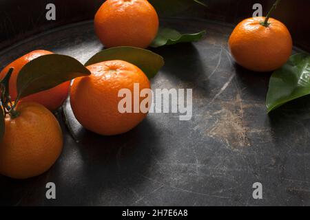 Five clementines with stems and leaves Stock Photo - Alamy