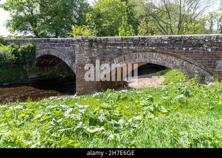 The red sandstone bridge begun in 1753 over the River Irthing at ...