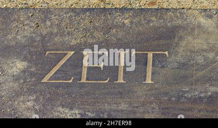 Engraved German word ZEIT partly covered in sand. Sands of Time Stock ...