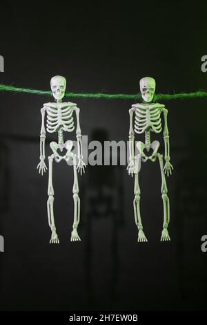 Decorative Skeletons hang on a rope in a children hands Stock Photo - Alamy