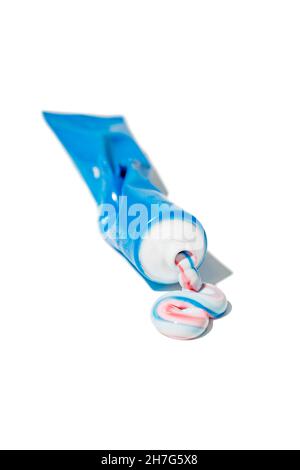 Dental blue tube with squeezed out toothpaste in white, red and blue ...