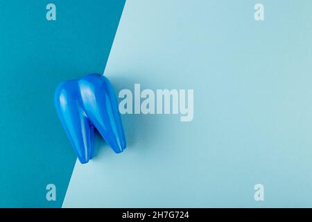 Large blue tooth lies on combined blue background Stock Photo - Alamy