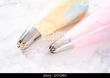 Colorful meringue in piping bags with metal tips Stock Photo - Alamy