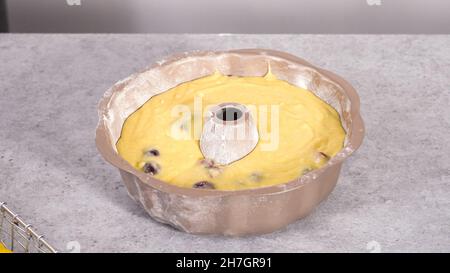 Step by step. Pouring cake batter into a bundt cake pan to bake a red ...