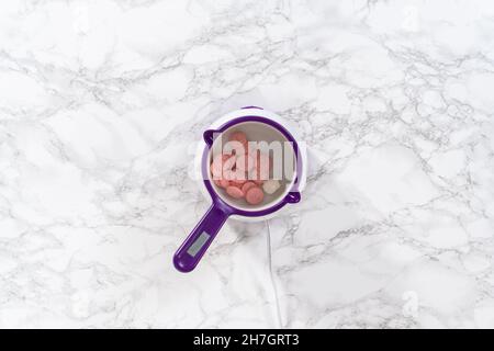 Melting chocolate in a cand melting pot to prepare mermaid chocolate ...