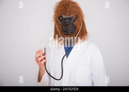 man in gorilla mask with doctor's coat and stethoscope on white ...