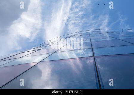 Elements of the glass facede skyscraper with reflecting sky and clouds ...