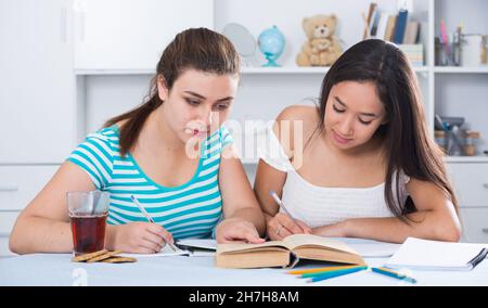 Teens girls doing homework and discussing Stock Photo - Alamy