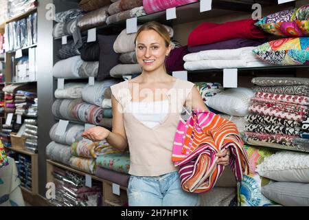 Adult female customer choosing blanket Stock Photo - Alamy