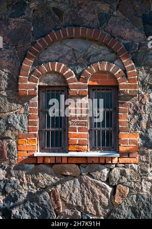 An old brick home with classic stone encased windows on a green grass ...