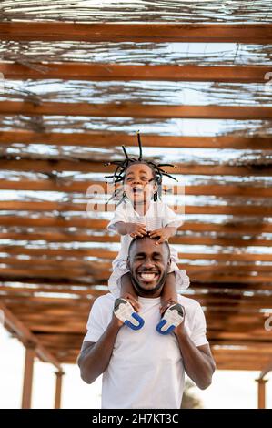 cheerful african american parents looking at preteen daughter with ...