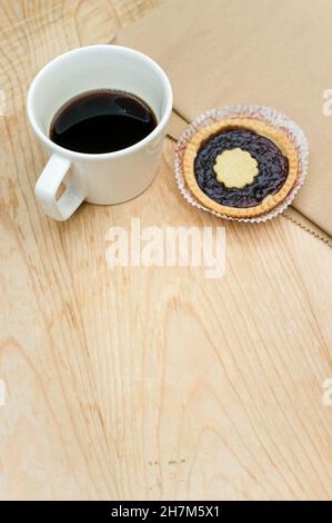 delicious jam short crust pastry and black coffee cup on a food paper ...