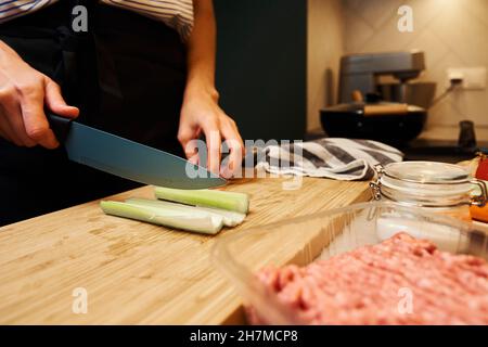 Woman with knife cuts fresh celery slices for cooking Stock Photo - Alamy