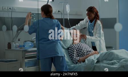 Multi ethnic medical staff running to help ill patient with oxygen tube ...