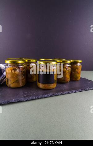 Chutney after courgette grew into marrow. Several jars black background ...