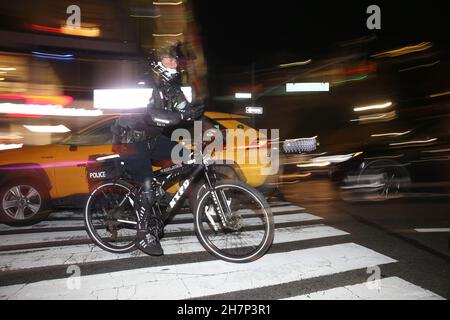 An NYPD officer wearing a riot gear helmet stands by in Times Square as ...